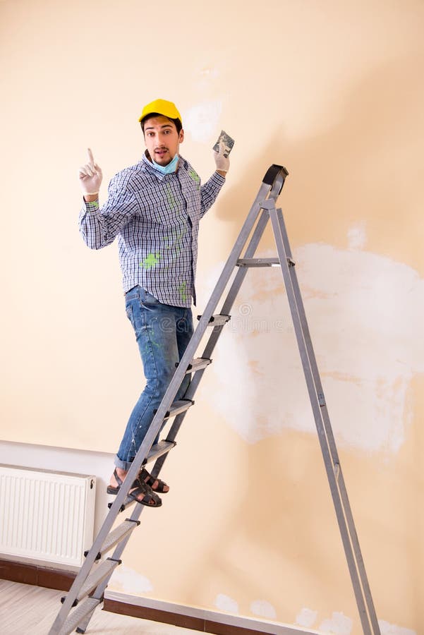 The Young Contractor Sanding Wall Down with Sandpaper Stock Photo ...