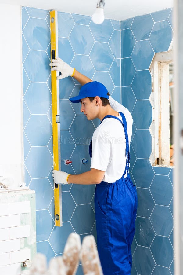 Contractor Inspecting Quality of Ceramic Tiles Laid with Level Meter ...