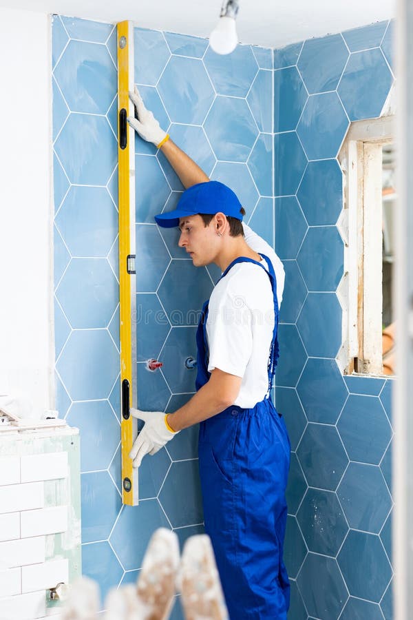 Contractor Inspecting Quality of Ceramic Tiles Laid with Level Meter ...