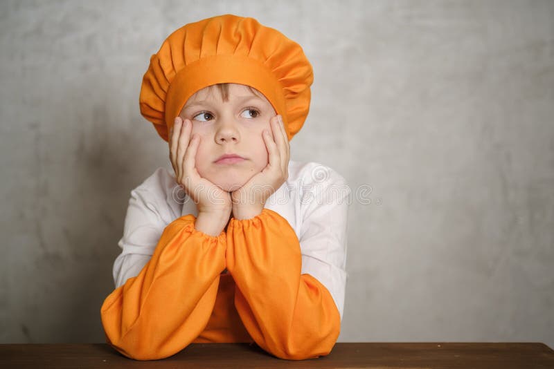 A Young Cook in an Orange Suit in a Thoughtful Pose Reflects on Cooking ...