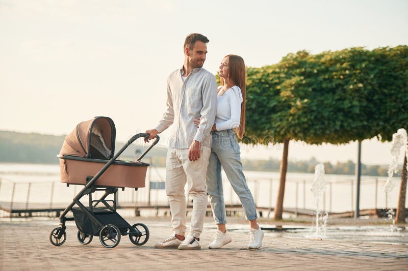 A Young Couple with a Baby Pram is Walking Together Stock Photo - Image ...