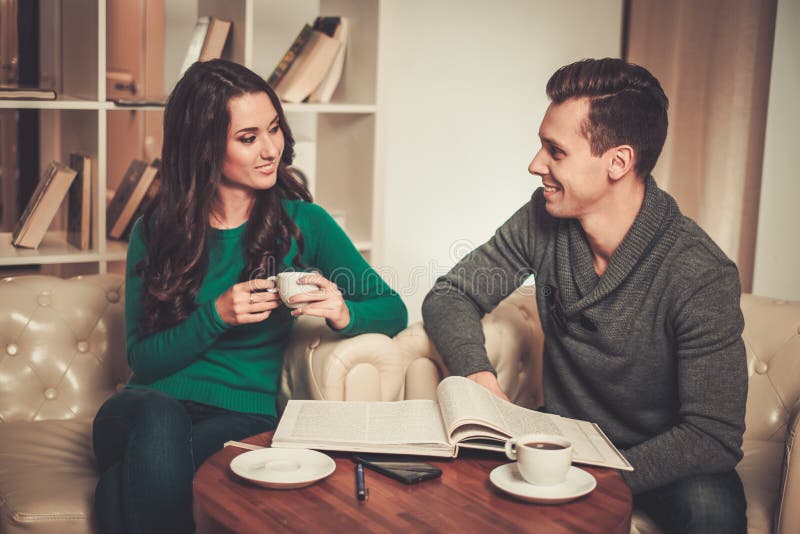 Young Couple Behind Table Discussing Stock Photo - Image of ...