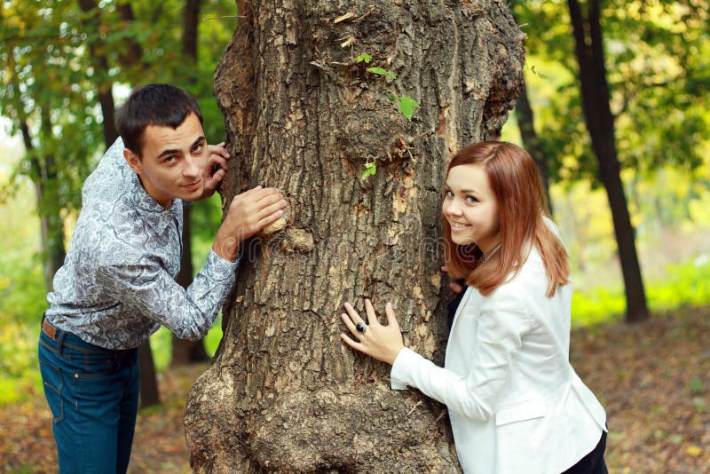 Young Couple Being Playful Around the Tree Stock Image - Image of ...