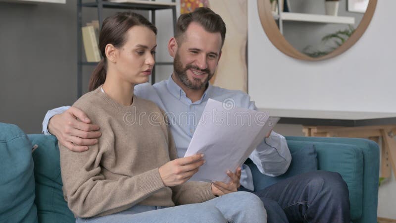 Couple Celebrating Success while Reading Documents on Sofa Stock Image ...