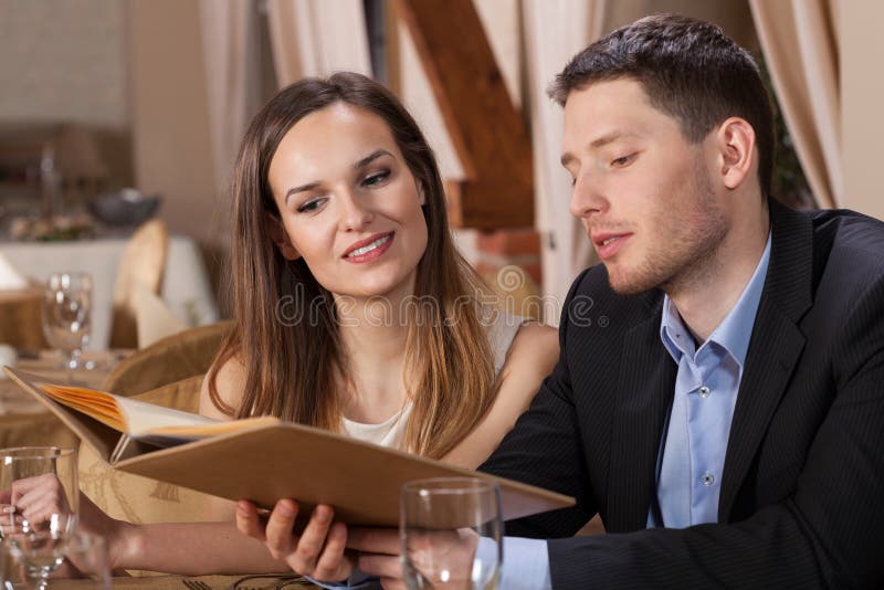 Young Couple Choosing from Menu Stock Image - Image of brunette ...