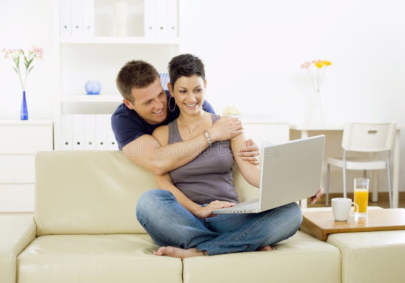 Cheerful Couple Using Laptop Together at Home Stock Photo - Image of ...