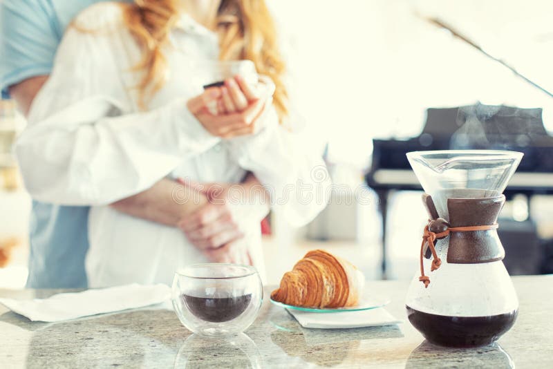 A Young Couple Cuddling in the Kitchen, Pour Over Coffee Maker on the ...