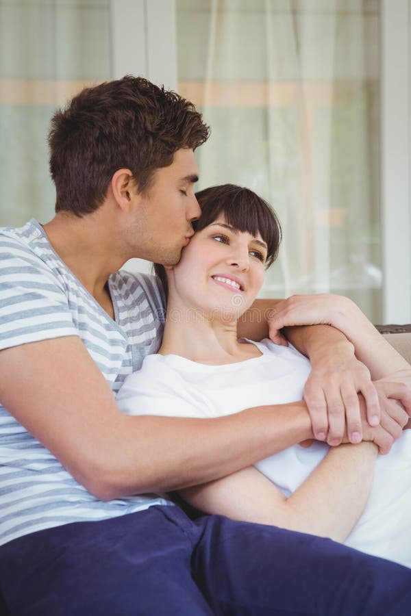Young Couple Cuddling on Sofa Stock Image - Image of household, house ...