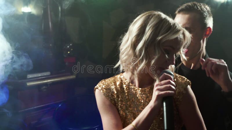 Young Couple Dancing and Singing with a Microphone in a Karaoke Bar ...