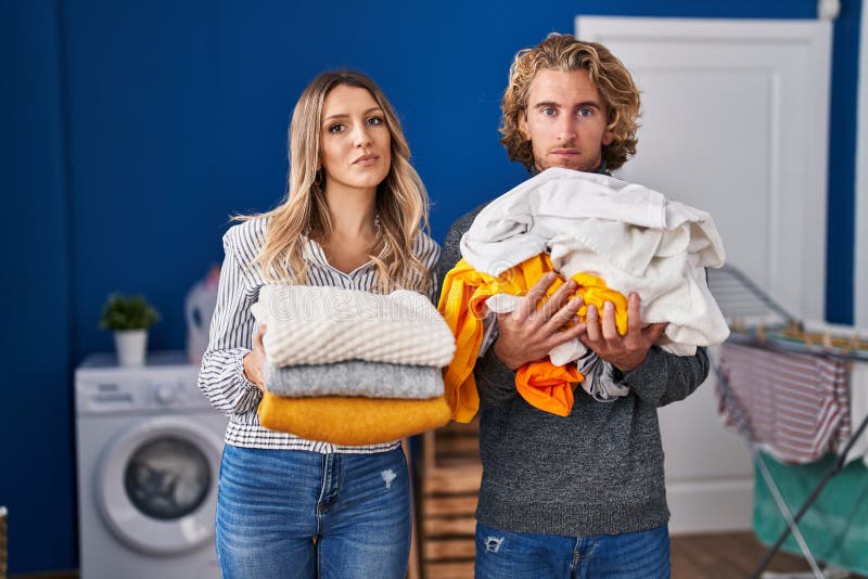Young Couple Doing Laundry Relaxed with Serious Expression on Face ...