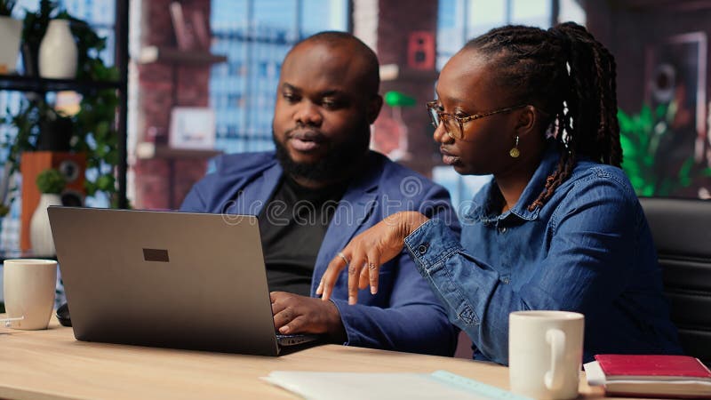 Young Couple Doing Teamwork and Multitasking on Laptop at Desk Stock ...
