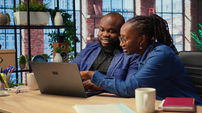 Young Couple Doing Teamwork and Multitasking on Laptop at Desk Stock ...