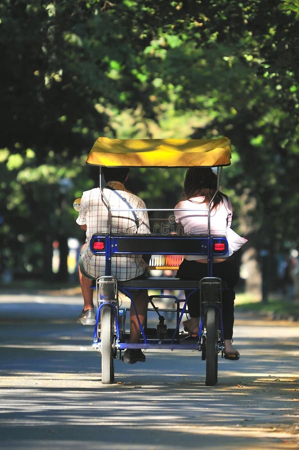 Young Couple Driving Tandem Bike in Park Stock Image - Image of ...