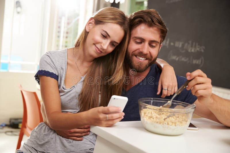 Young Couple Eating Breakfast Whilst Using Mobile Phones Stock Photo ...