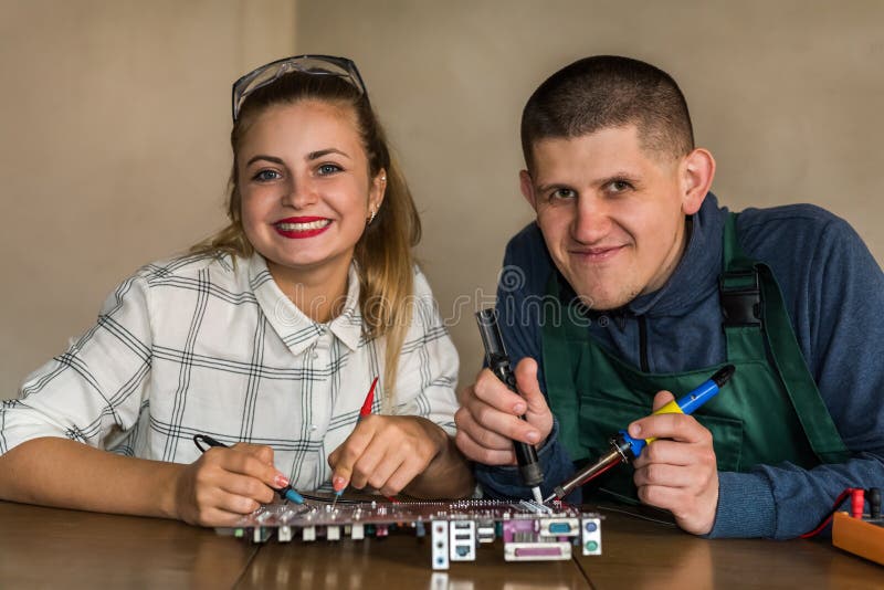 Young Couple of Engineers Repairing Computer Device Stock Photo - Image ...