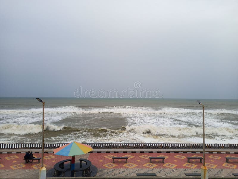 Young Couple Enjoying a Beautiful View of Ocean Waves while Sitting on ...