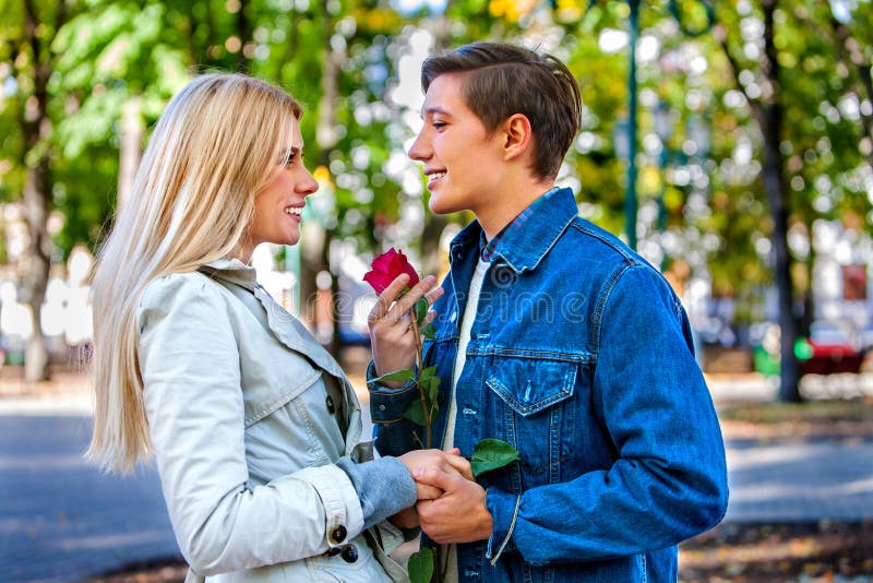 Young Couple with Flower Hugging and Flirting in Stock Photo - Image of ...