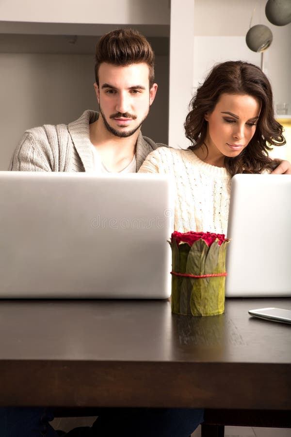 Young Couple in Front of Their Laptop Computers at Home Stock Photo ...