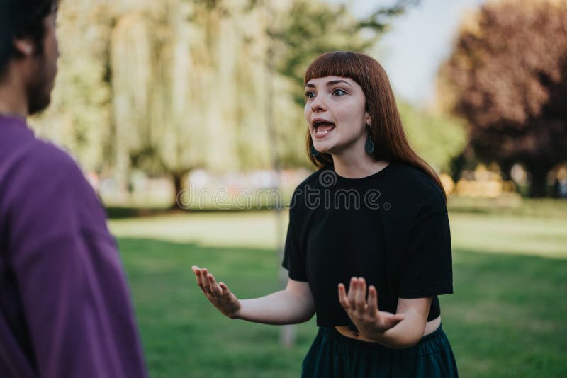 Young Couple Having a Discussion in a Park on a Sunny Day Stock Photo ...