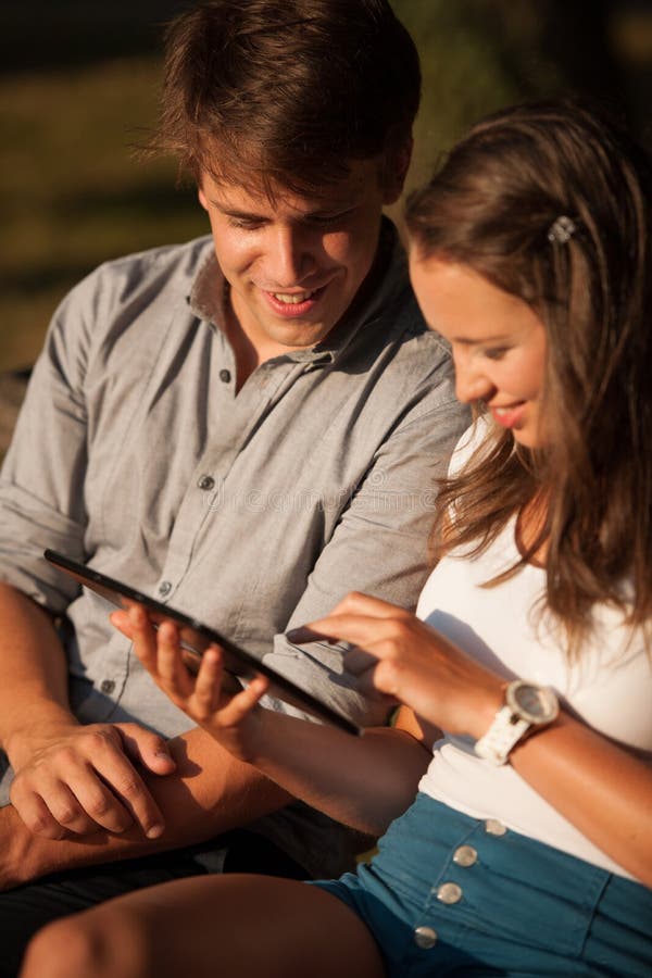 Young Couple Having Fun on a Bench in Park while Socializing Over Web ...