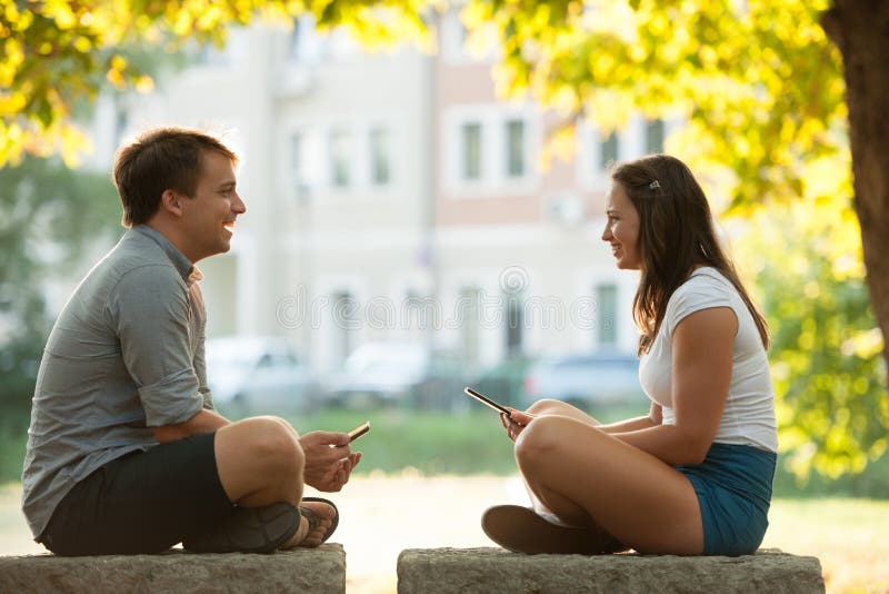 Young Couple Having Fun on a Bench in Park while Socializing Over Web ...
