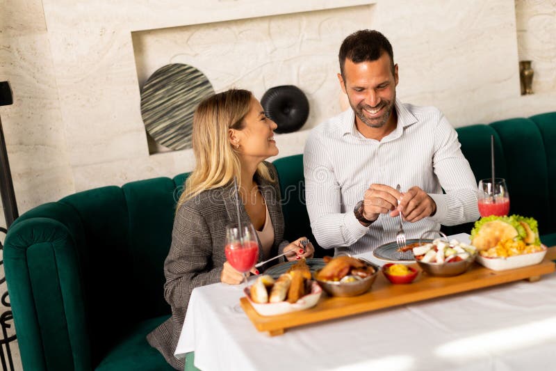 Young Couple Having Lunch and Drinking Fresh Squeezed Juice in the ...