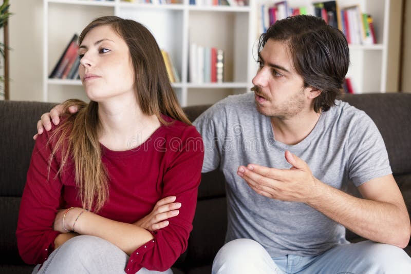 Young Couple Is Having A Quarrel While Sitting On Sofa At Home Stock