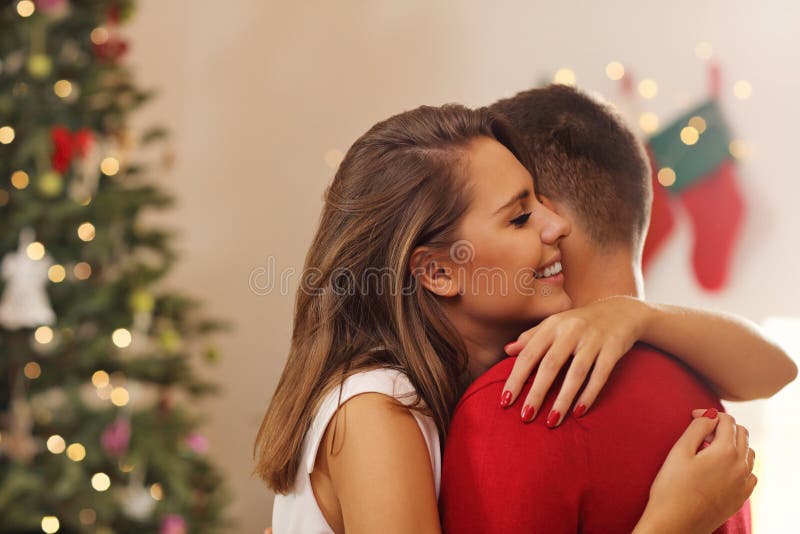 Young Couple Hugging Over Christmas Tree Stock Photo - Image of kissing ...