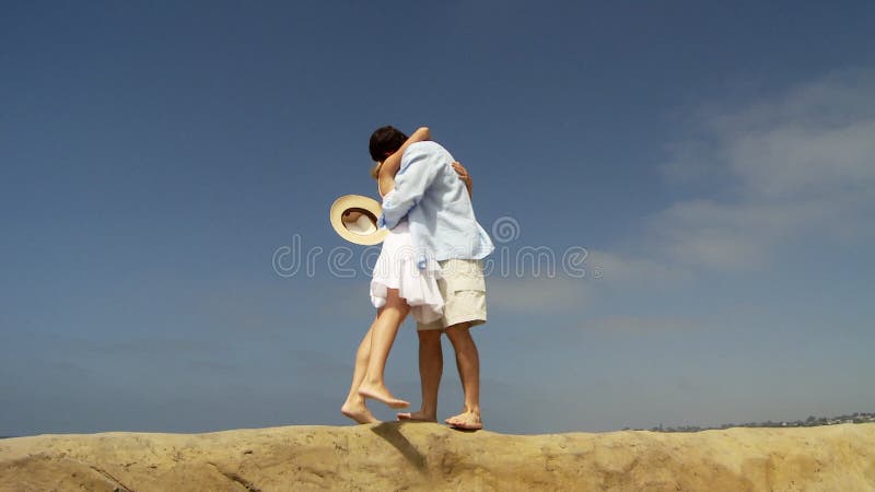Young Couple Kissing on Berm at Beach and Falling Off Stock Footage ...