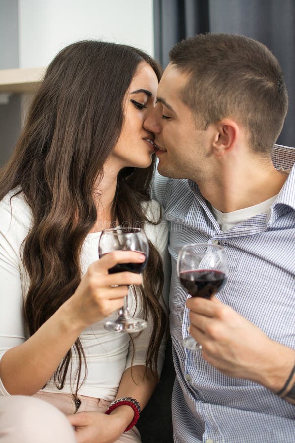 Young Couple Kissing and Drinking Red Wine. Stock Image - Image of indoors, love: 312362779