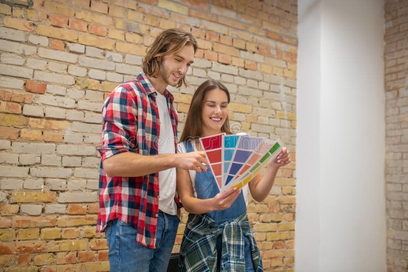 Young Couple Looking at Color Palette and Choosing the Wall Color Stock ...