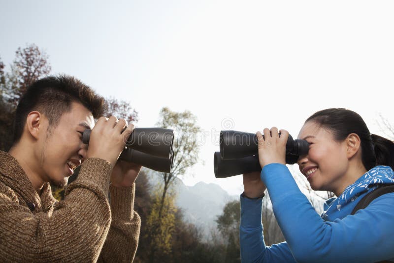 Young Couple Looking at Each Other through Binoculars Stock Photo ...