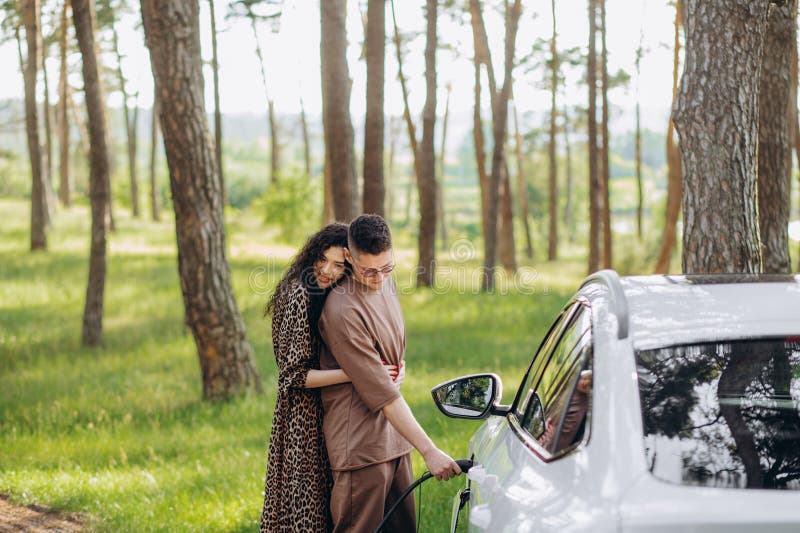 Young Couple in Love Charges an Electric Car Stock Photo - Image of ...