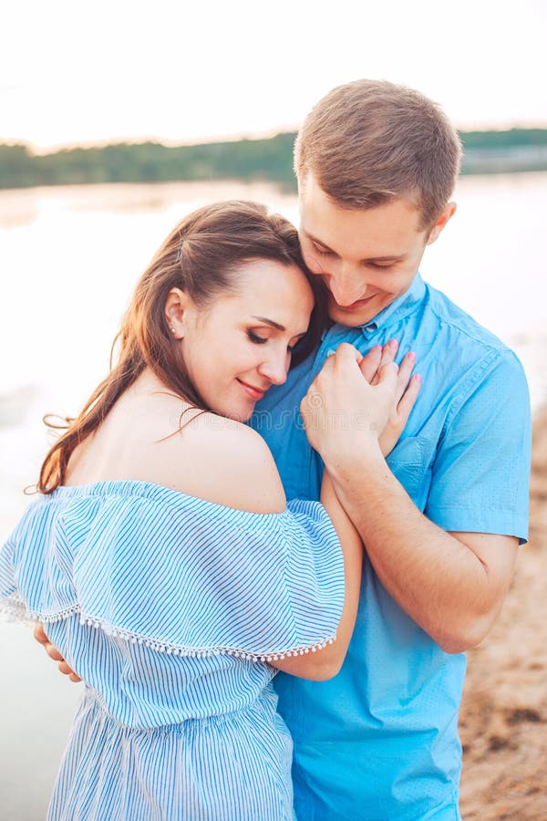 Young Couple In Love Hug Each Other At The Lake Outdoor In Summer Day