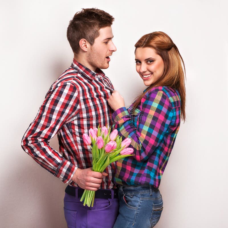 Young Couple In Love Make A Heart And Hands Are Holding Tulips Stock