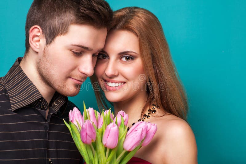 Young Couple In Love Make A Heart And Hands Are Holding Tulips Stock