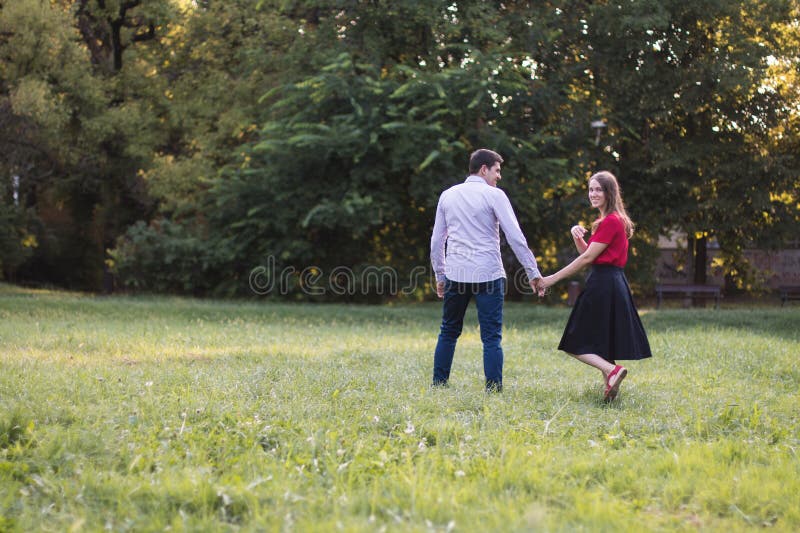 Young Couple In Love Walking In The Park Holding Hands Stock Image