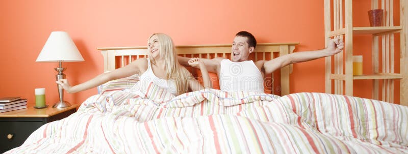 Young Couple Lying in Bed Stretching Stock Image - Image of affection ...