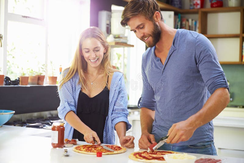 Young Couple Making Pizza in Kitchen Together Stock Image - Image of ...