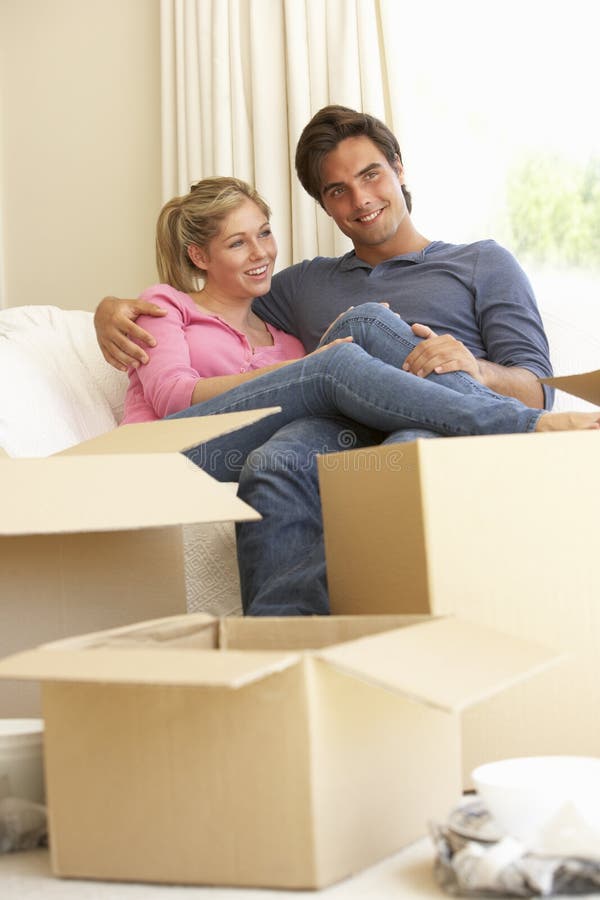 Young Couple Moving into New Home Surrounded by Packing Boxes Stock ...