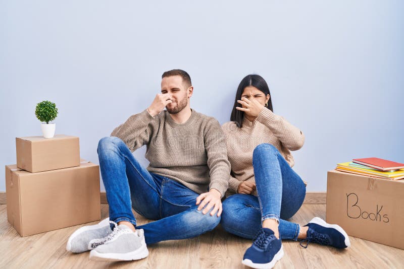 Young Couple Moving To A New Home Smelling Something Stinky And
