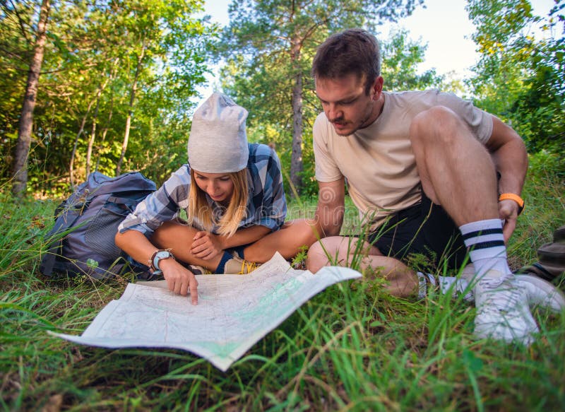 Young Couple Navigasting Using Map and Compass Inside the Forest Stock ...