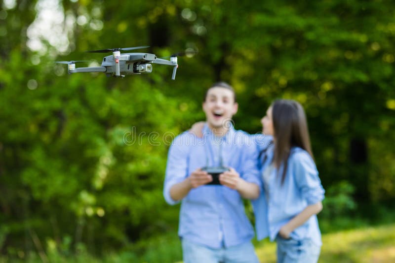 Young Couple Navigating a Flying Drone with Remote Control. Man and ...