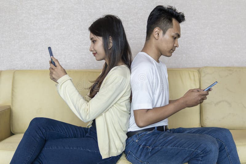 Young Couple Not Talking To Each Other they are Busy Using Smartphone ...