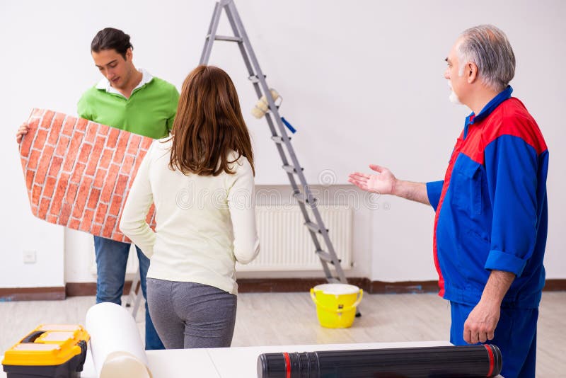 Young Couple and Old Contractor in Home Renovation Concept Stock Photo ...