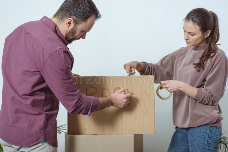 Young Couple Packing Boxes while Moving Stock Photo - Image of female ...