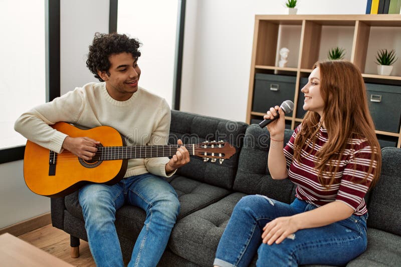 Young Couple Playing Classical Guitar and Singing Using Microphone at ...