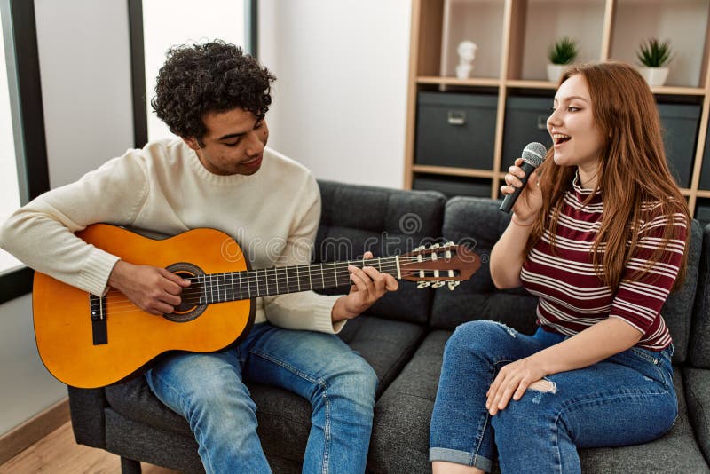 Young Couple Playing Classical Guitar and Singing Using Microphone at ...