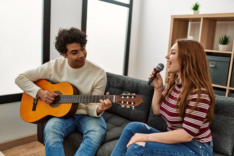 Young Couple Playing Classical Guitar and Singing Using Microphone at ...