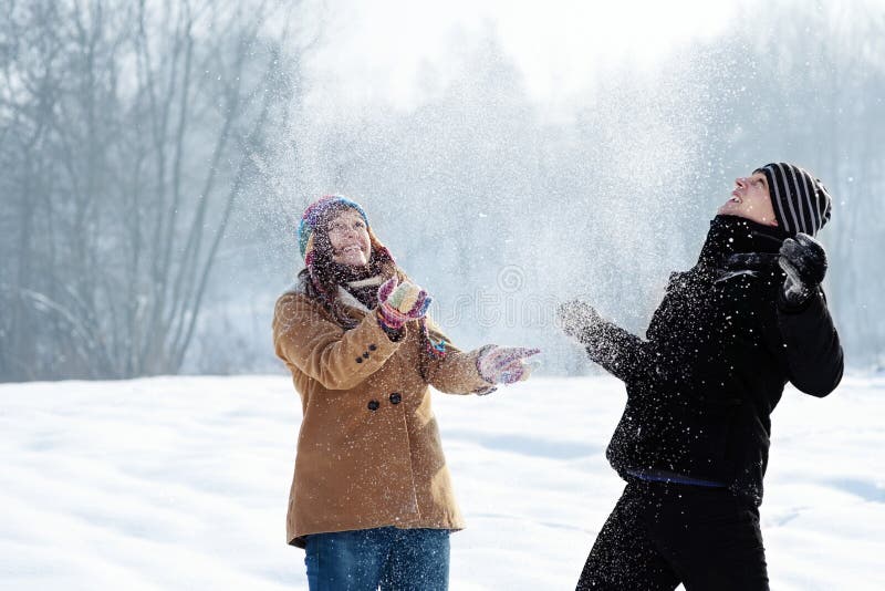 Couple Playing with Snow and Girlfriend Throwing a Ball Stock Photo ...